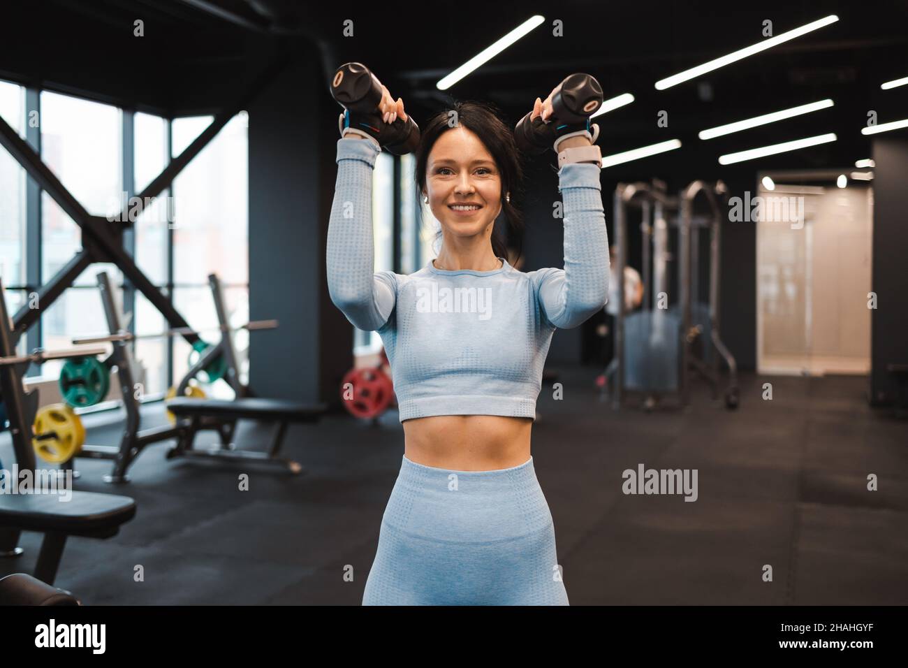 Beautiful fitness girl doing exercises with dumbbells in the gym Stock ...