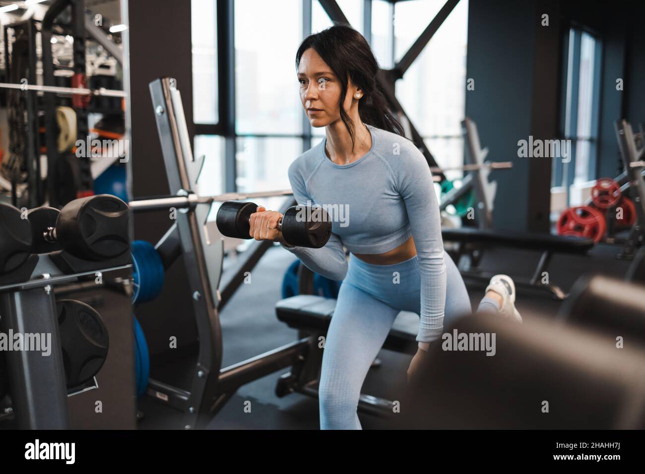 Woman shakes biceps doing exercises with dumbbells Stock Photo - Alamy
