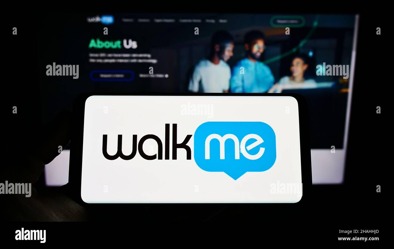 Person holding smartphone with logo of US software company WalkMe Ltd ...