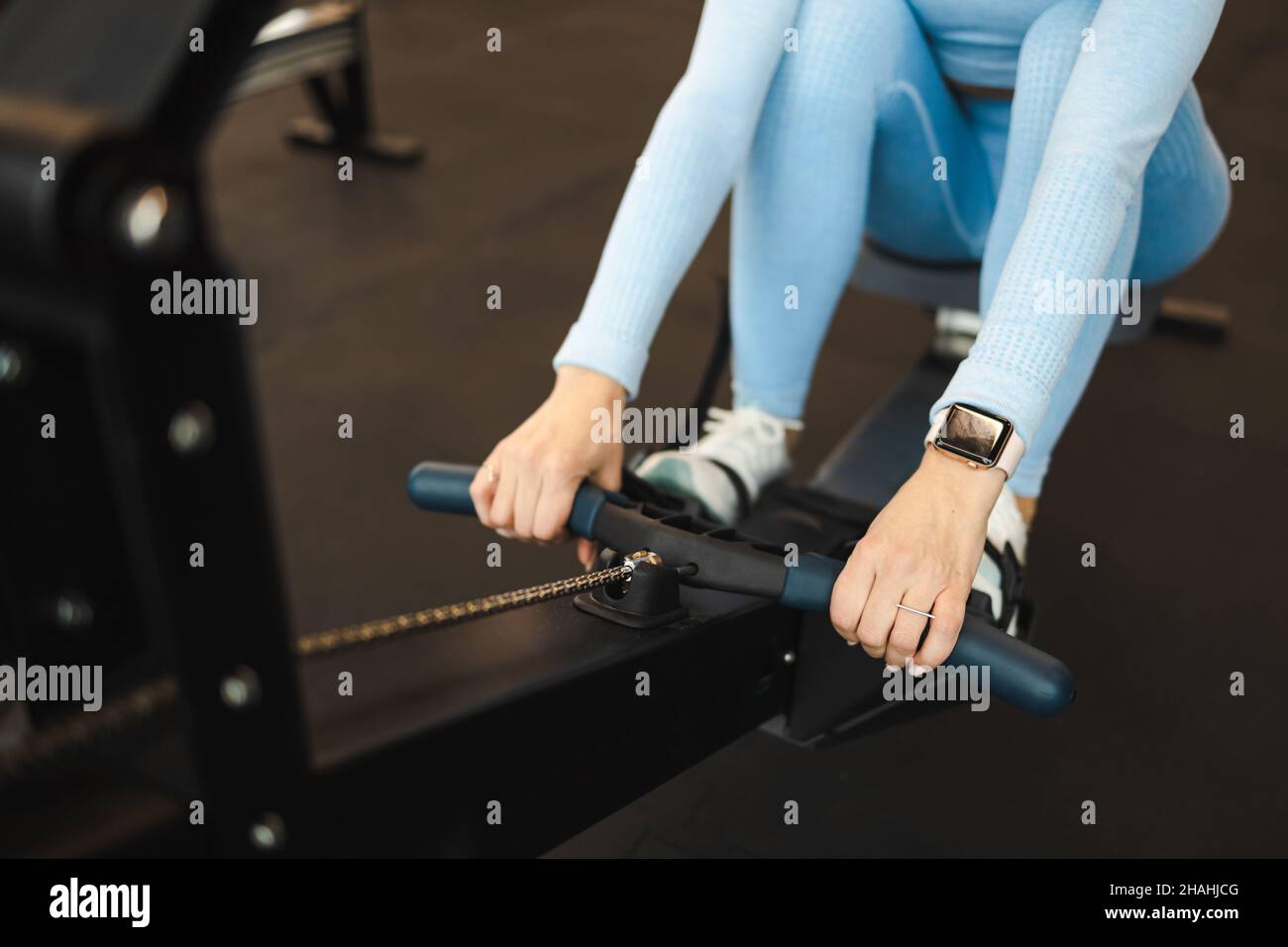 Woman in blue sportswear working out on a rowing machine Stock Photo ...