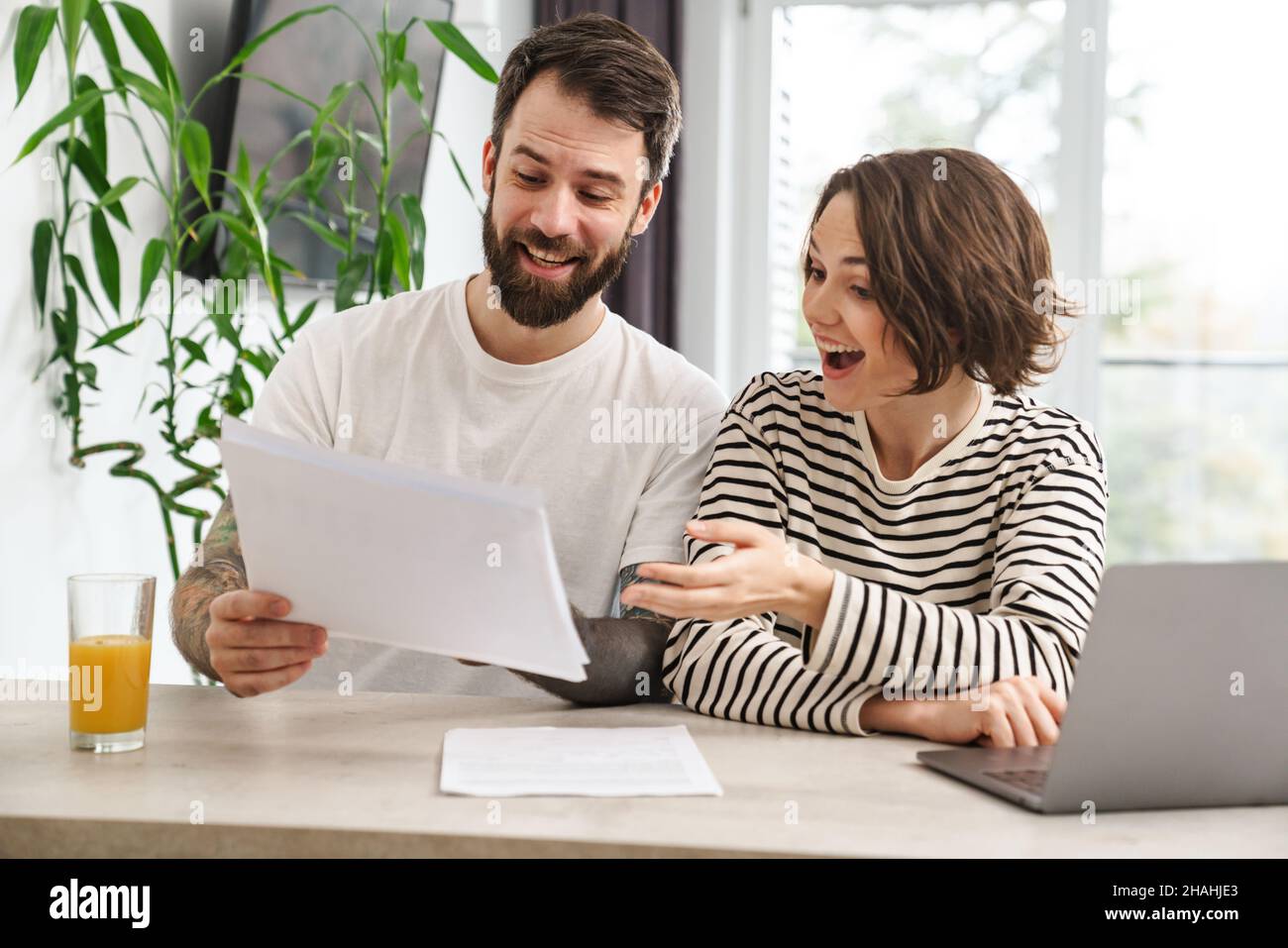 Young happy white couple working together with laptop computer and ...
