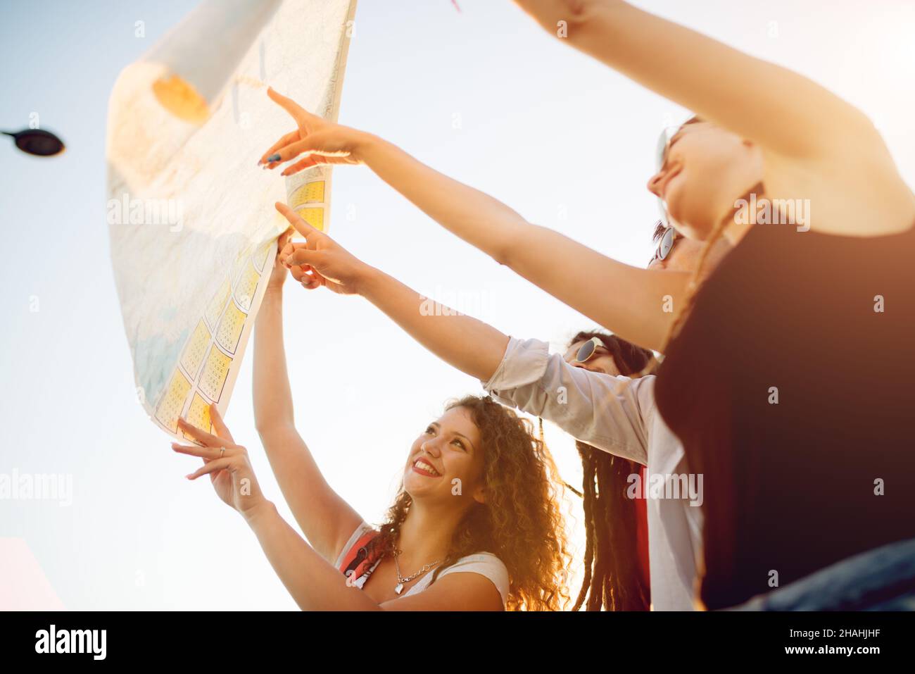 Group of young tourists are together looking on the map Stock Photo - Alamy