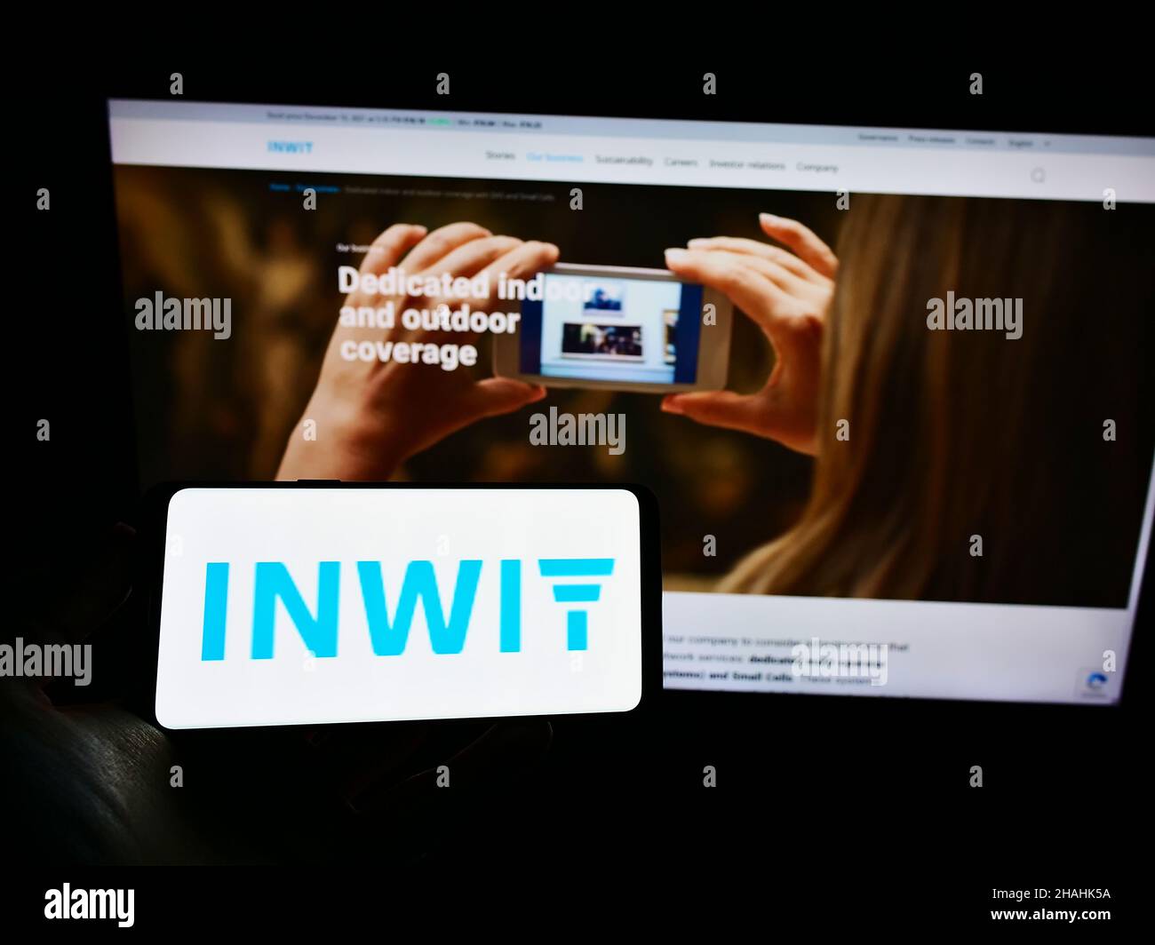 Person holding mobile phone with logo of Italian infrastructure company ...