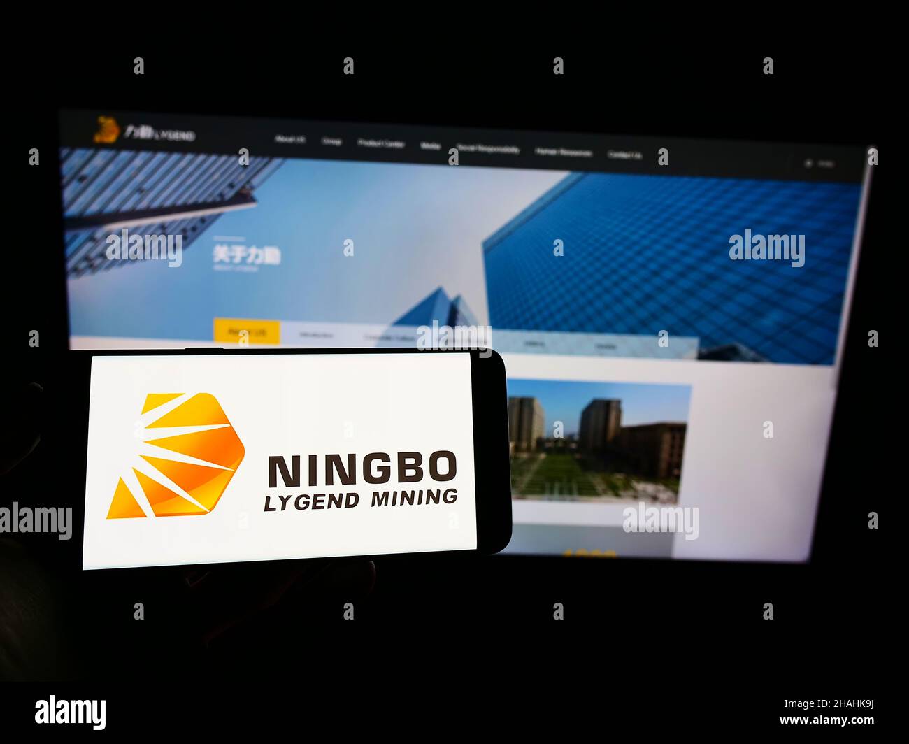 Person holding cellphone with logo of mining company Lygend Resources ...