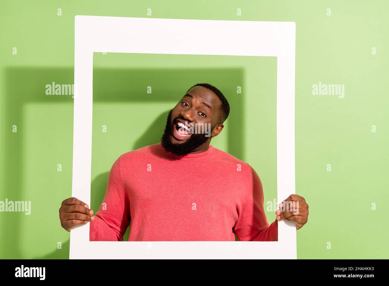 Portrait of cheerful comedy show host hands hold instant photo frame ...
