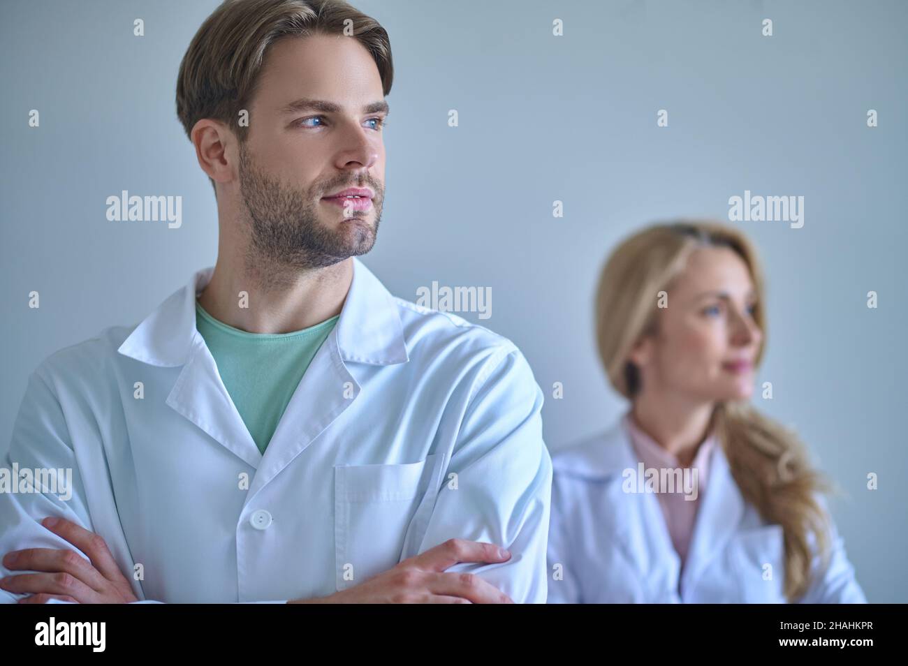 Man thinking looking to side and woman behind Stock Photo - Alamy