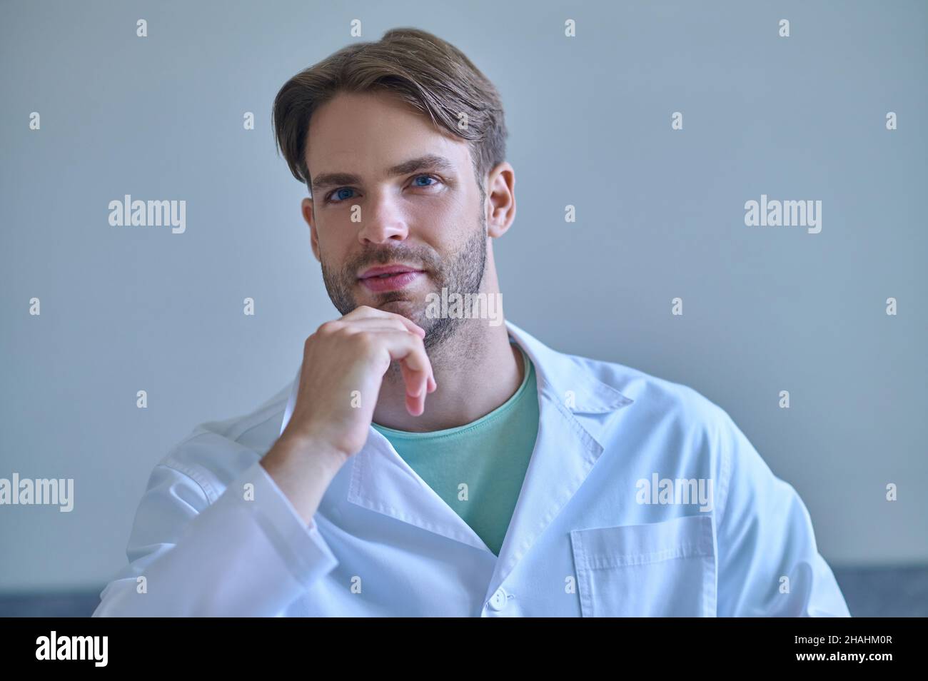 Thinking man touching chin with his hand Stock Photo - Alamy