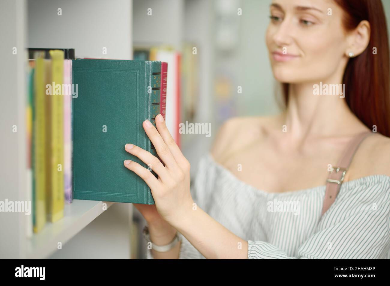 Young woman putting book on hi-res stock photography and images - Alamy