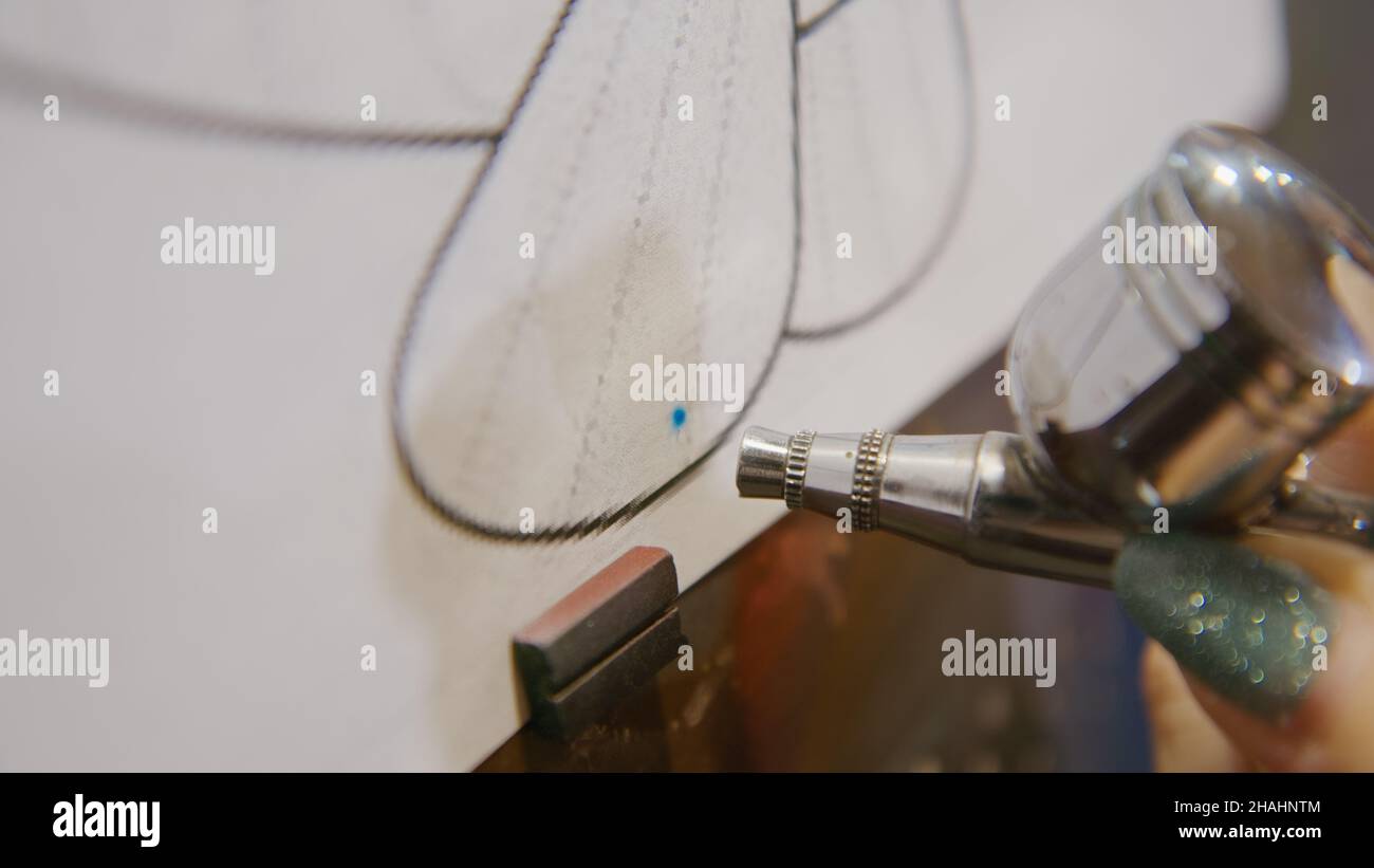 Woman artist learns to paint with airbrush with acrylic dye, paper and ...