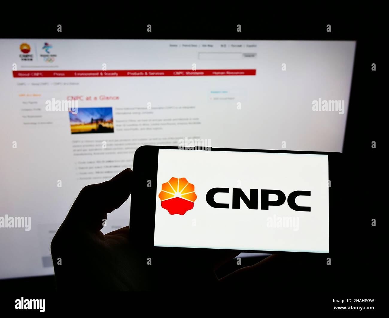 Person holding mobile phone with logo of company China National ...
