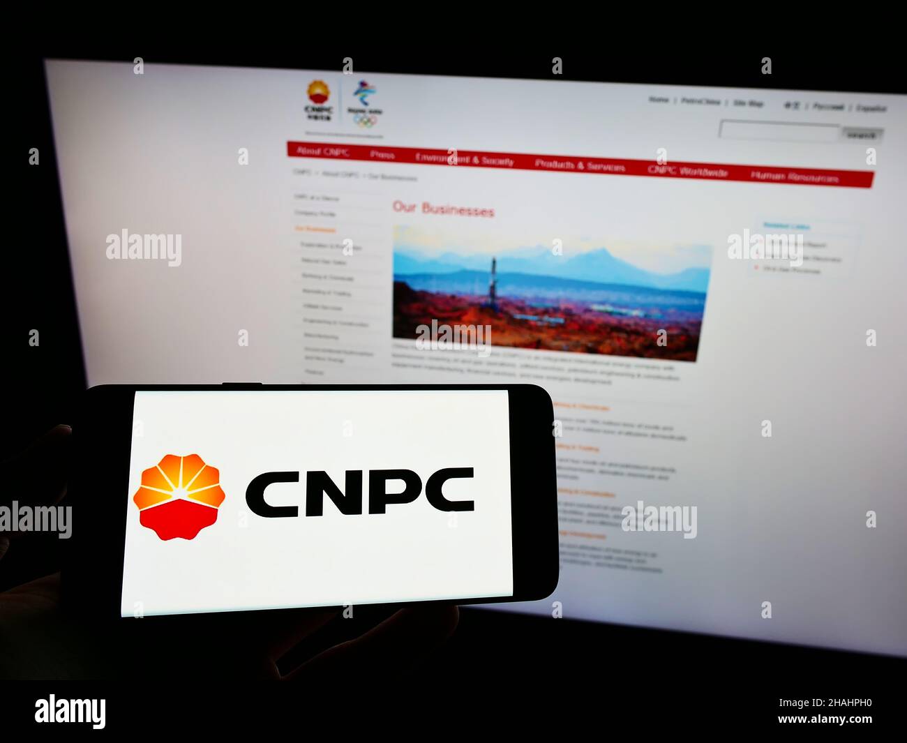 Person holding cellphone with logo of company China National Petroleum ...
