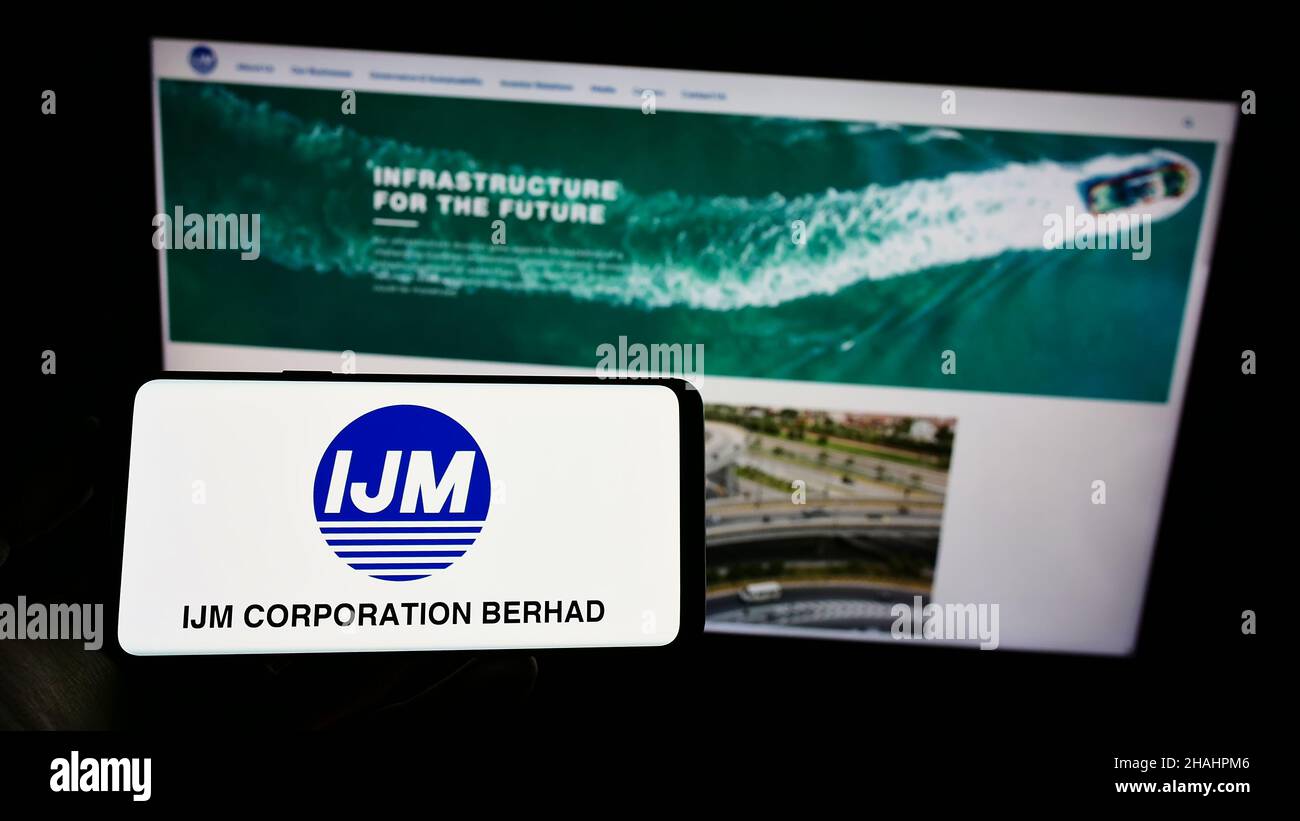 Person holding cellphone with logo of Malaysian conglomerate IJM ...