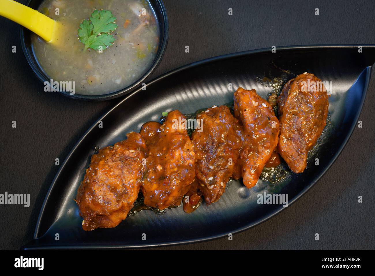 Picture of pan fried chicken stuffed momo served in a black plate along ...