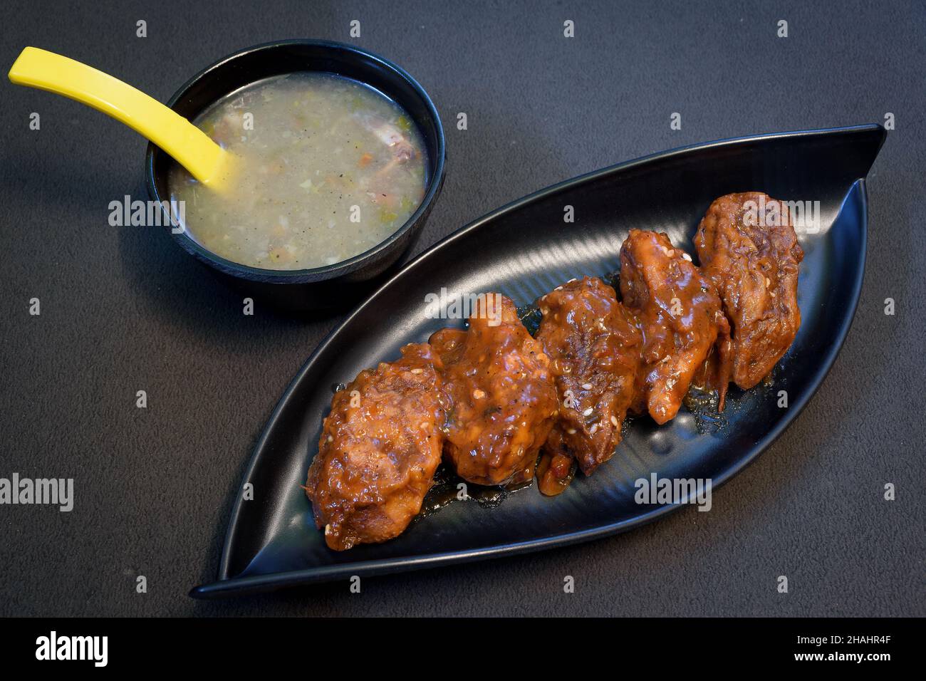 Picture of pan fried chicken stuffed momo served in a black plate along ...