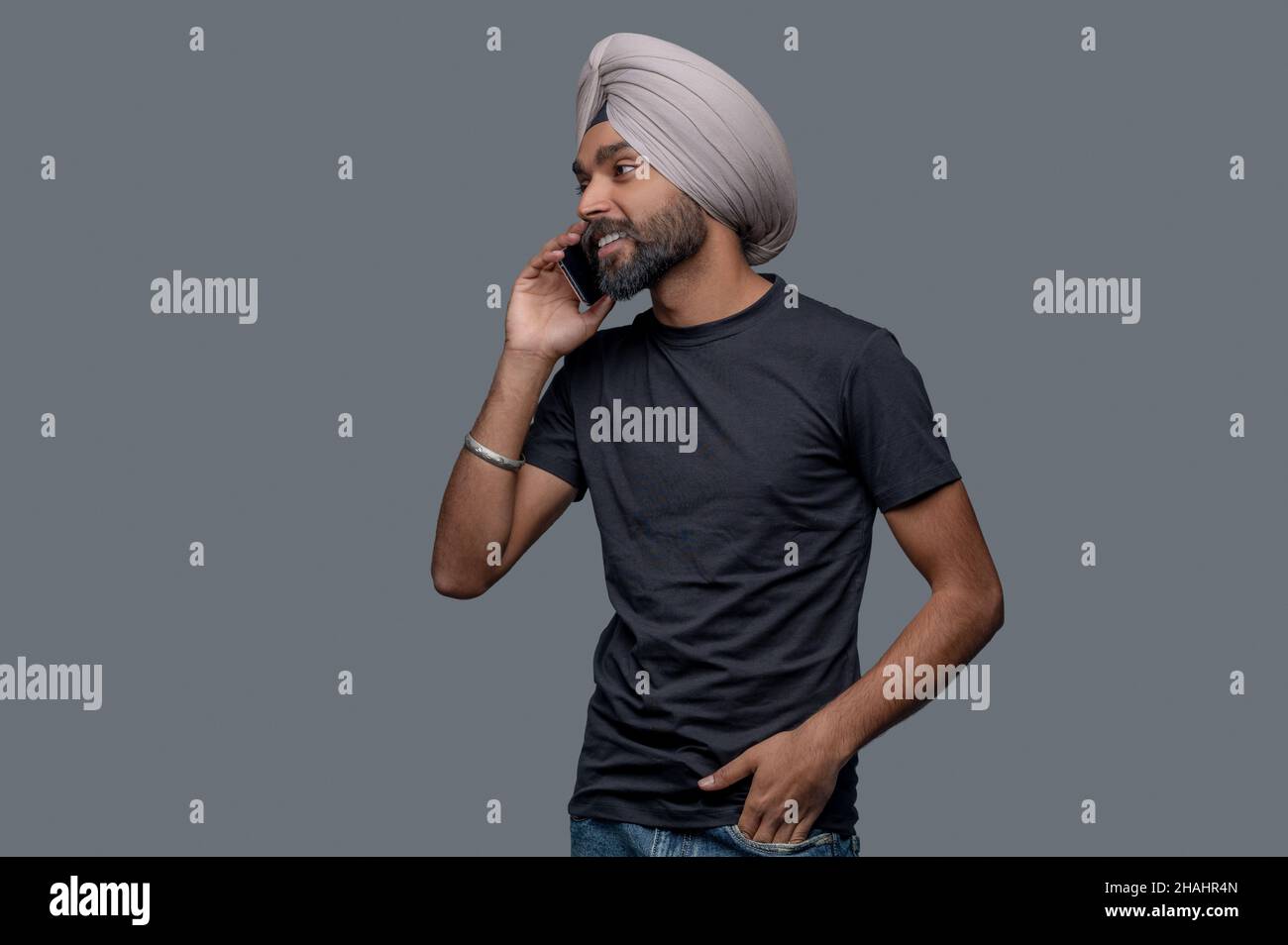 Joyous attractive Indian man having a phone conversation Stock Photo ...