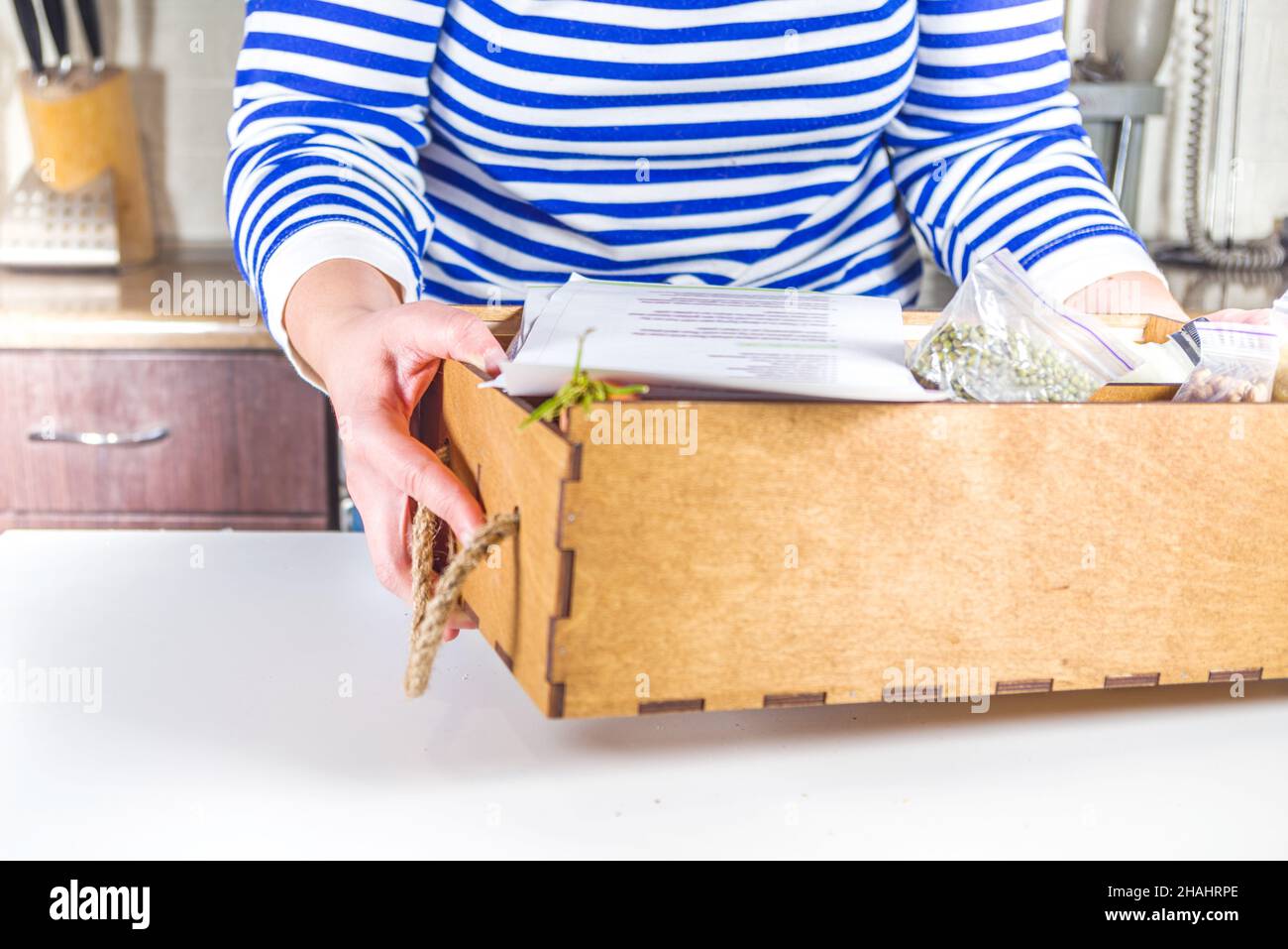 Caucasian woman take apart box with delivery of ingredients, recipes ...