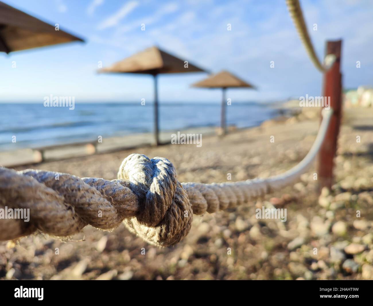 Rope fence with knot on summer beach background Stock Photo - Alamy