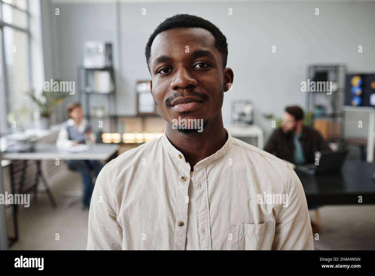 Close-up of African young manager looking at camera while working at ...