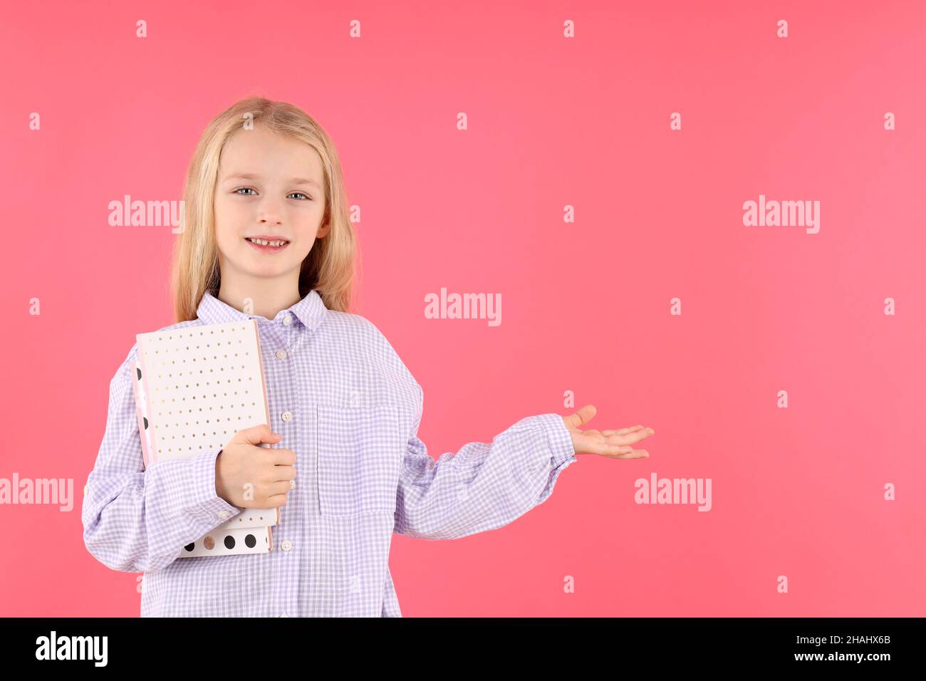 Cute little girl with notebooks on pink background Stock Photo - Alamy