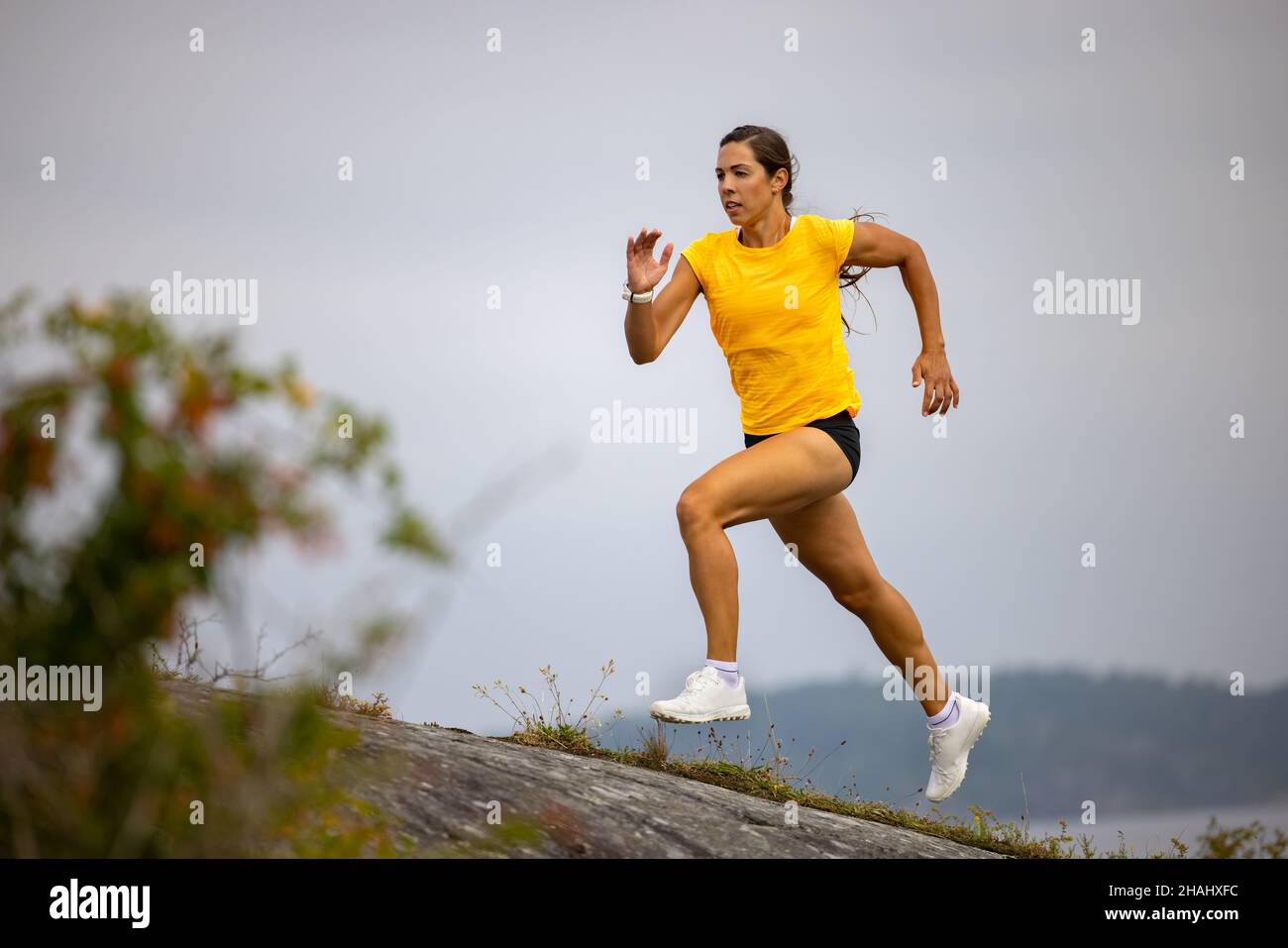 Focused fitness woman doing high-intensity running on mountainside by ...