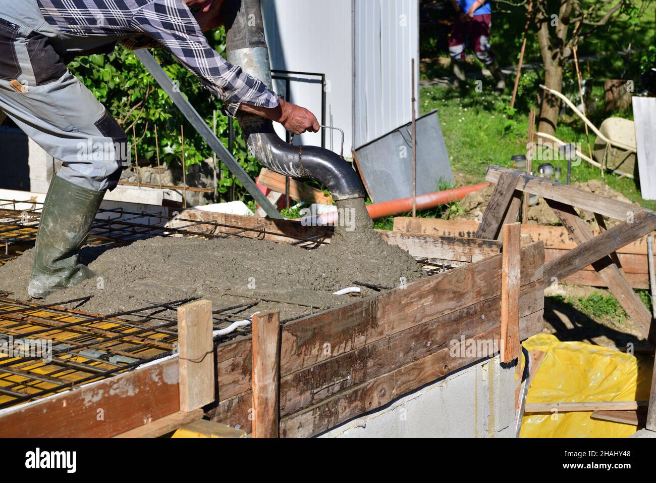 A concrete worker on a construction site concretes walls using a ...