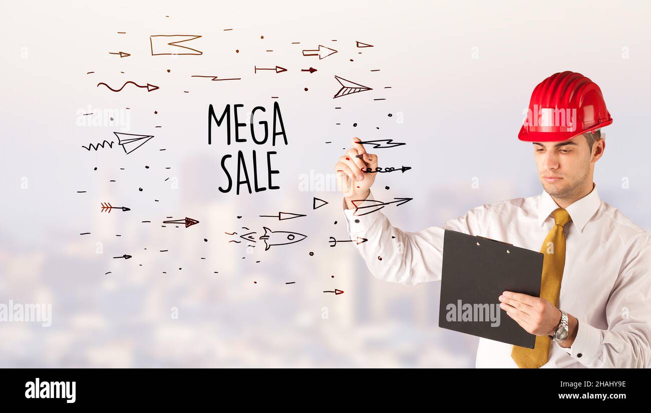 Young businessman with helmet drawing sale sign Stock Photo - Alamy