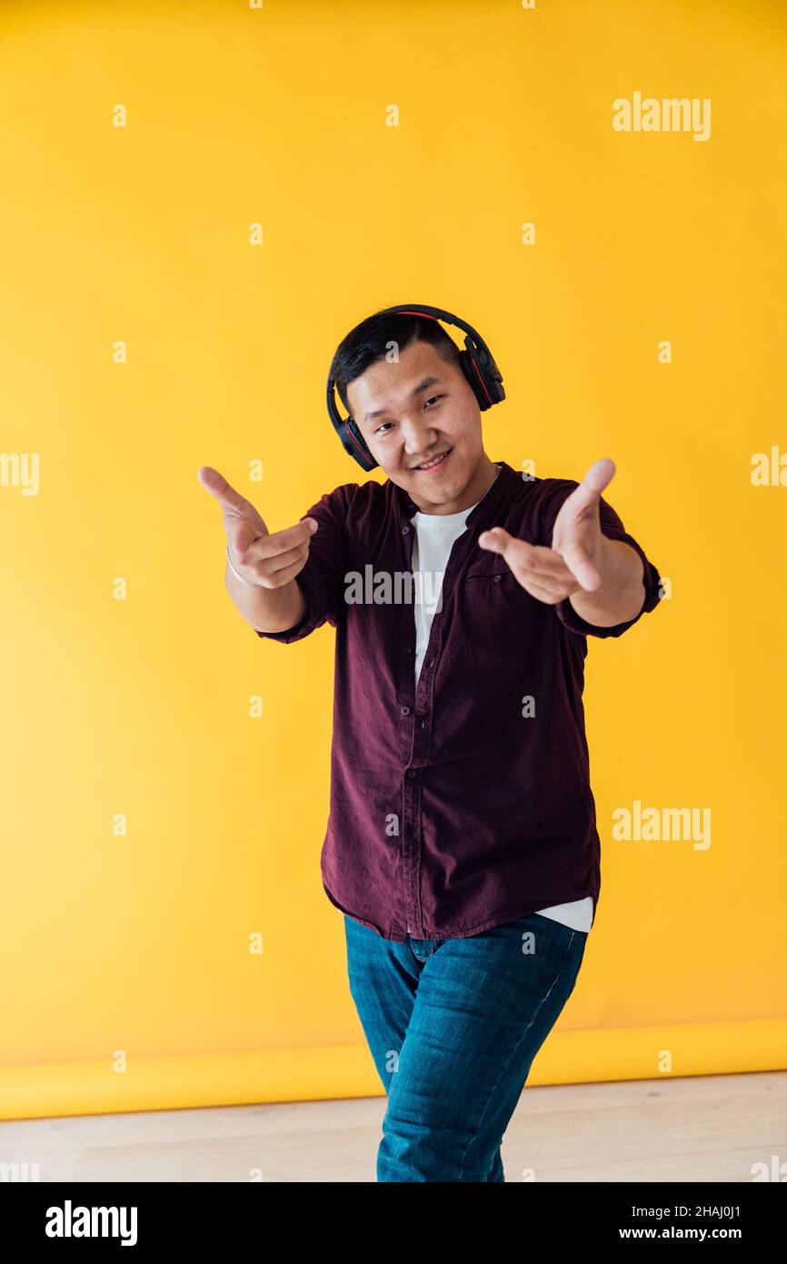 Asian man dancing to music with headphones Stock Photo - Alamy