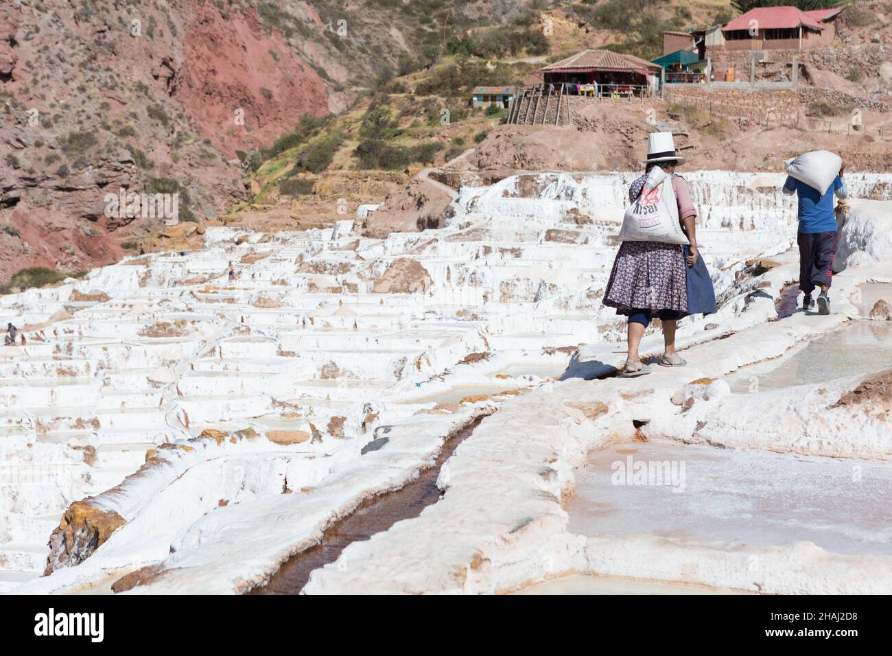 Salt pans at Salinas. A worker carries salt along the terraces Stock ...