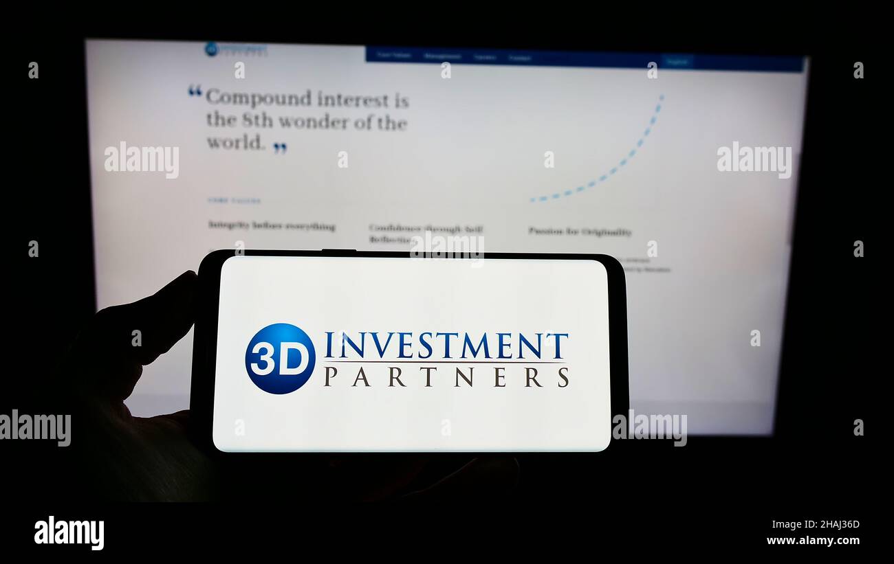 Person holding mobile phone with logo of Singaporean company 3D ...