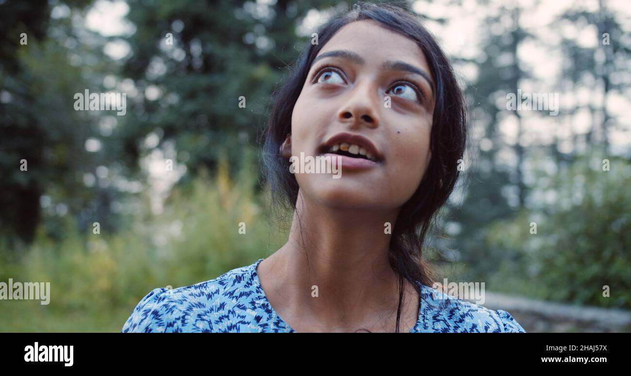 Portrait of a South Asian female outdoors looking up Stock Photo - Alamy