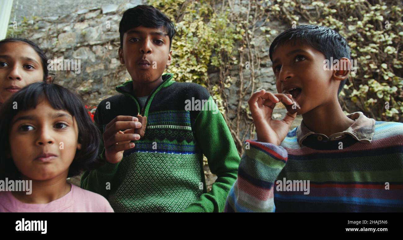 South Asian kids standing outdoors and eating chocolates Stock Photo ...