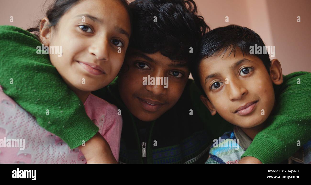 South Asian kids hugging each other and looking at the camera Stock ...
