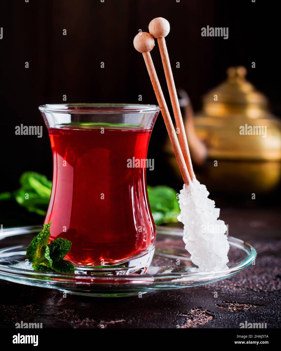 Turkish tea in traditional glass cup with caramelized sugar and mint on ...