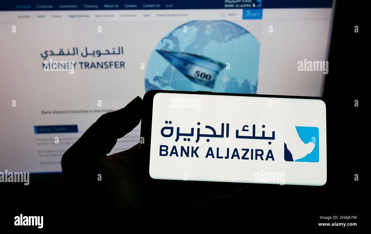 Person holding mobile phone with logo of Saudi Arabian company Bank ...