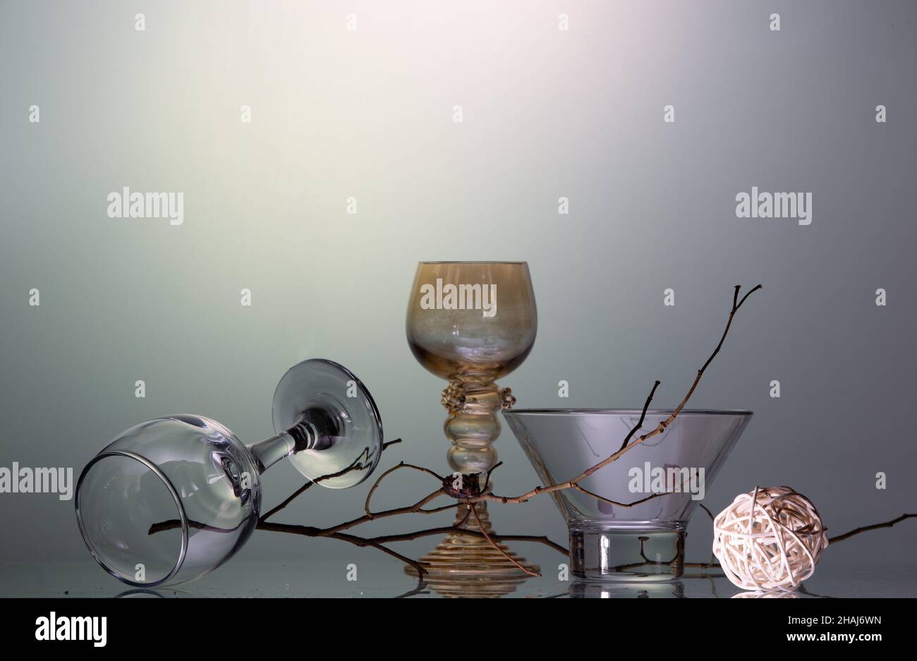 Still life with glassware and a dry tree branch Stock Photo - Alamy