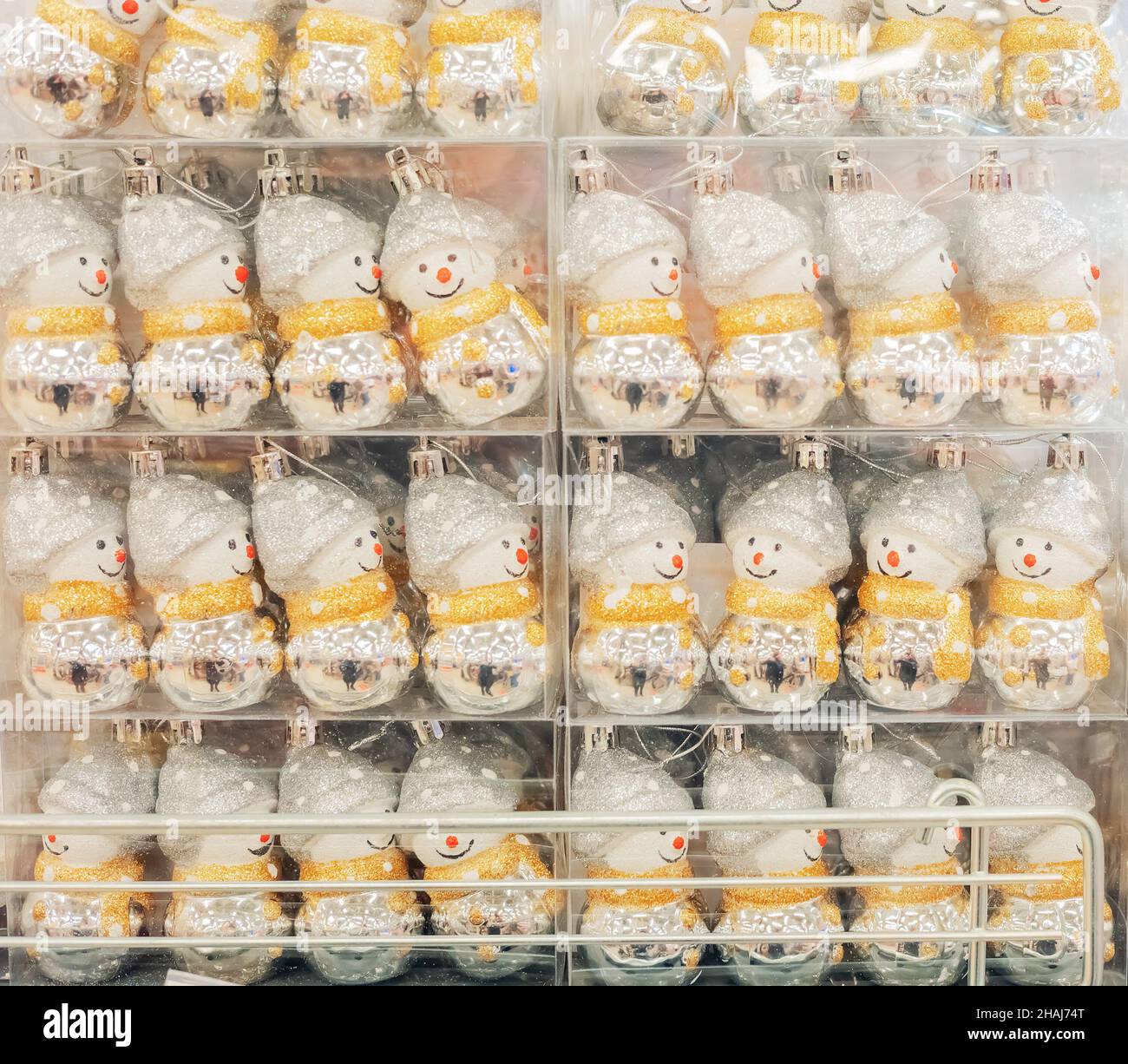 Lots of shiny snowmen are lined up in row in a shop window. Christmas ...