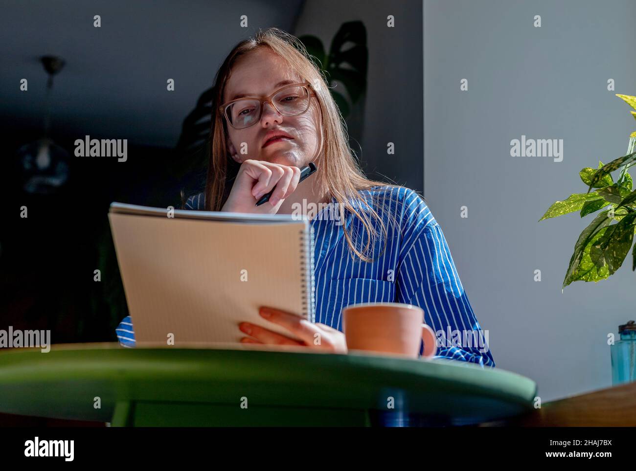 Young smart woman in glasses reading book and studying in cafe. Female ...