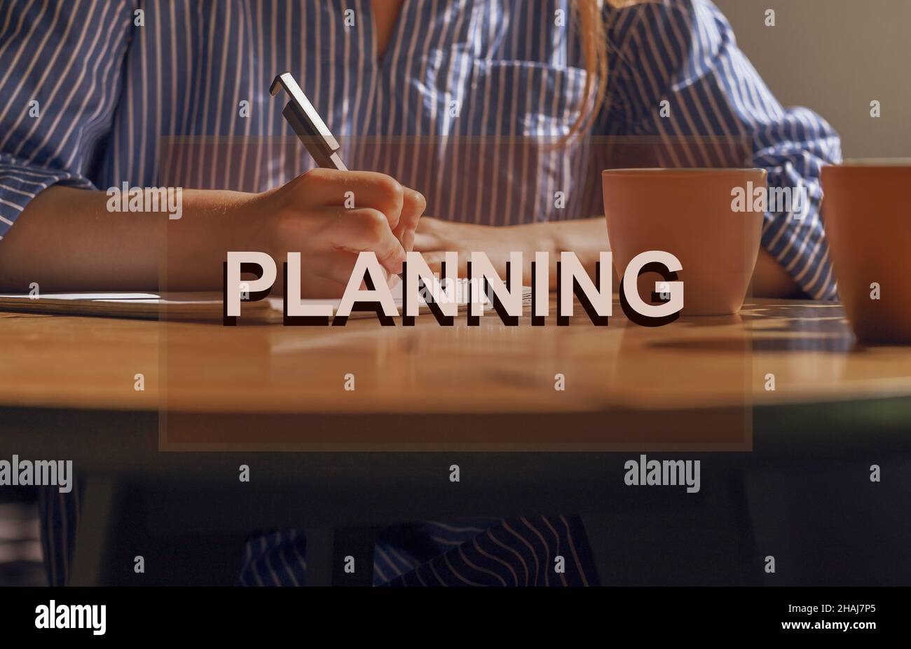 Planning concept. Writing notes, plans in notebook on wooden table with ...