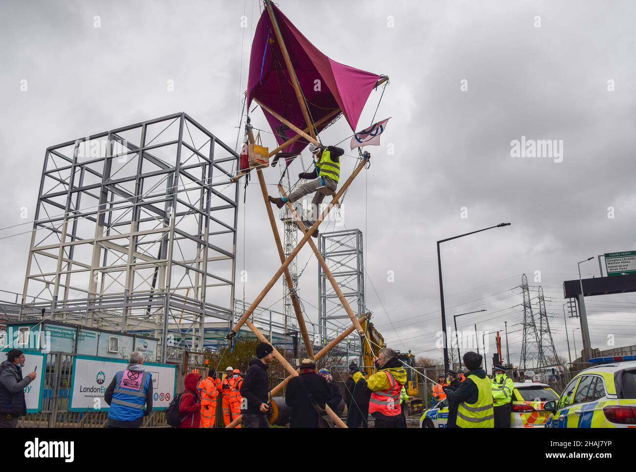 London, UK. 13th Dec, 2021. A protester sits on a bamboo structure ...