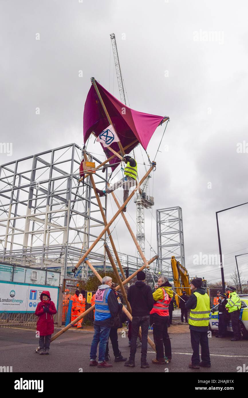 London, UK. 13th Dec, 2021. A protester sits on a bamboo structure ...