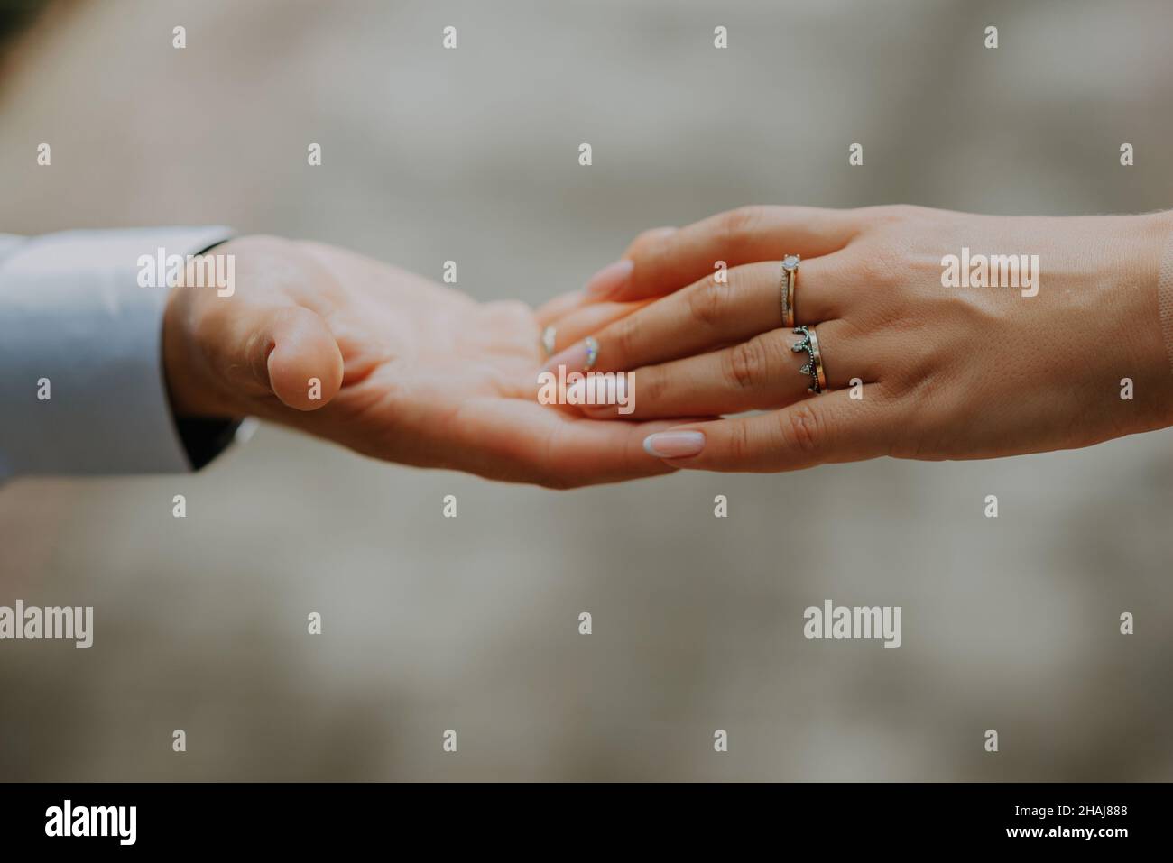 Wedding couple holding hands on sunset. Wedding rings. Man giving an ...