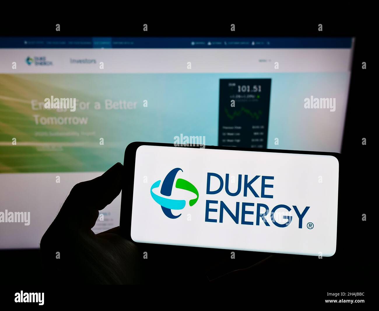 Person holding smartphone with logo of US power and gas company Duke ...