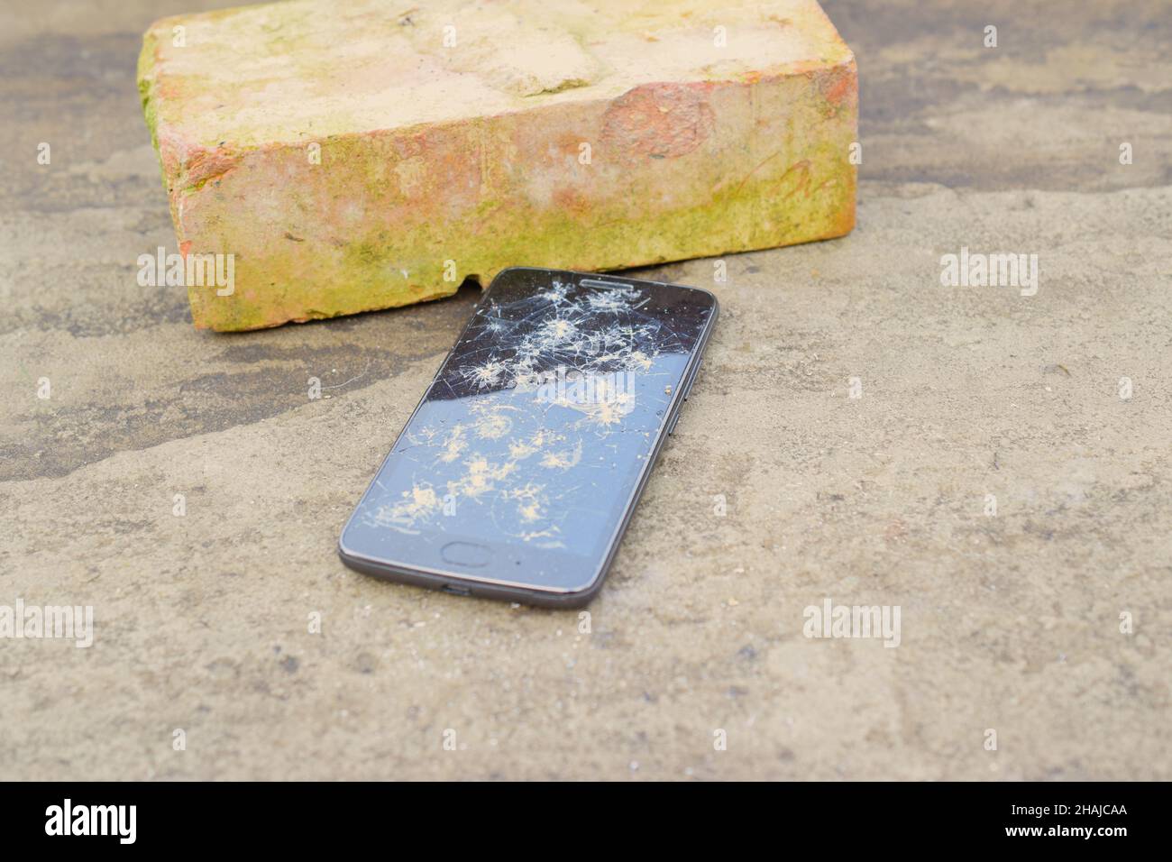 Smashed cell phone and a brick Stock Photo - Alamy
