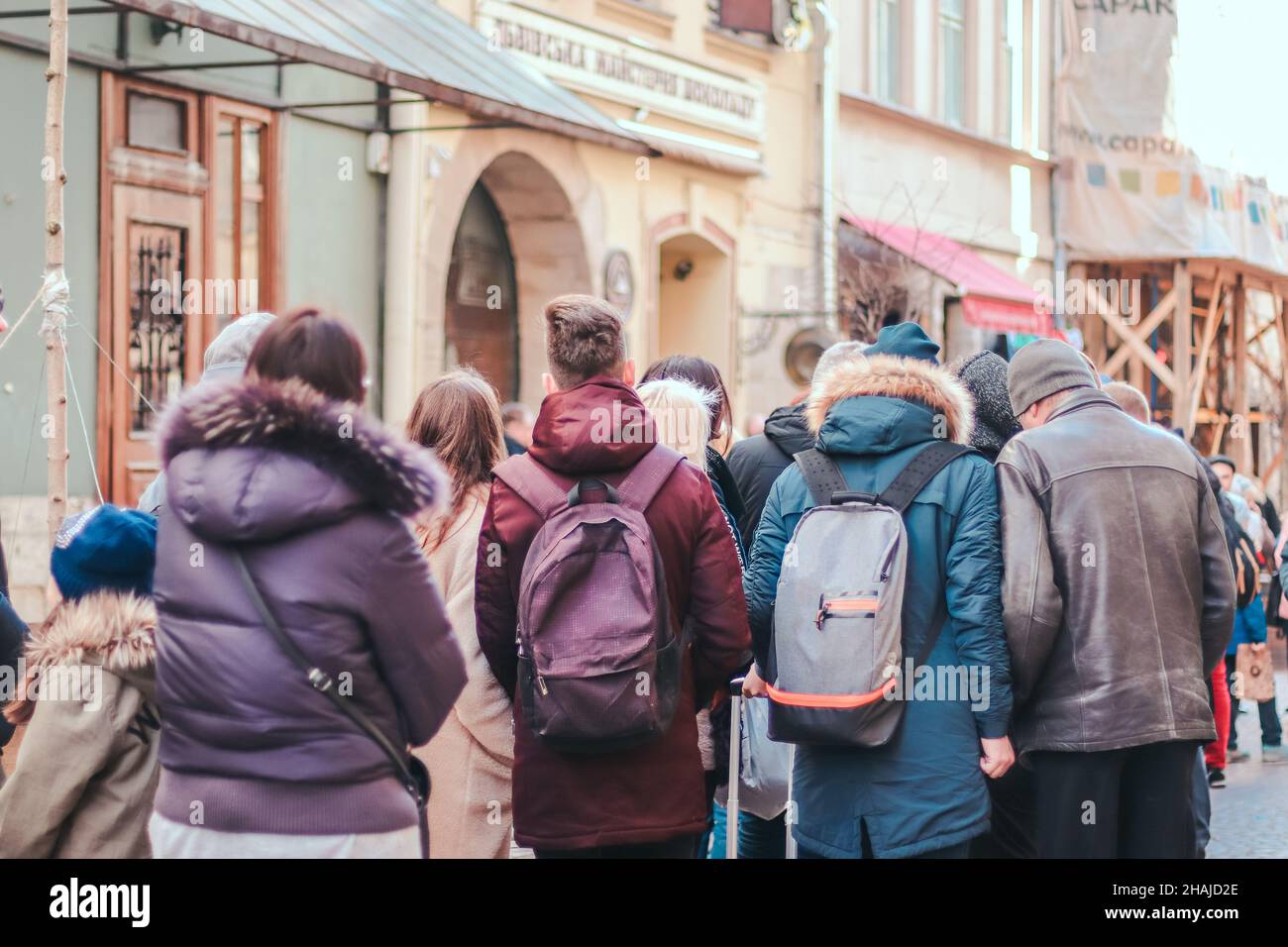 Anonymous crowd of people stand in line at a store, mall during a ...