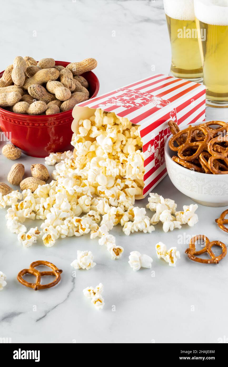 A vertical view of containers of snacks with glasses of beer in behind ...
