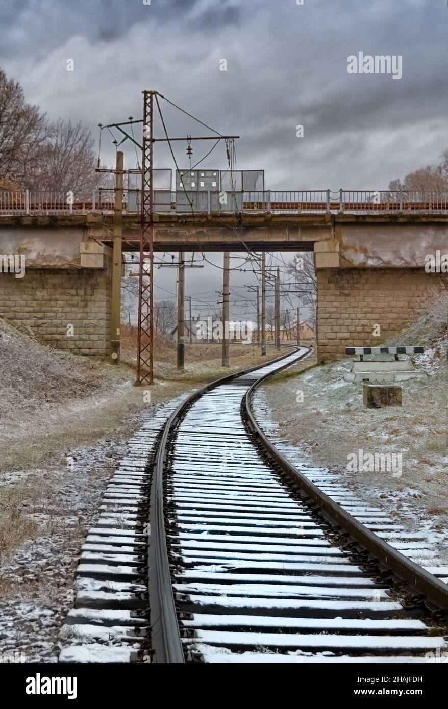Old brick stone arch bridge spanning over a branch line railway track ...