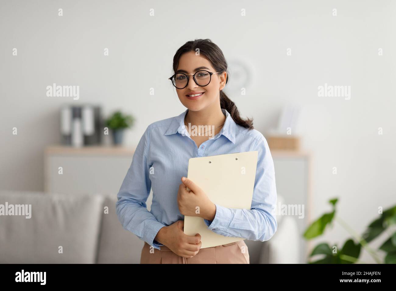 Portrait of happy middle eastern female psychologist smiling at camera ...