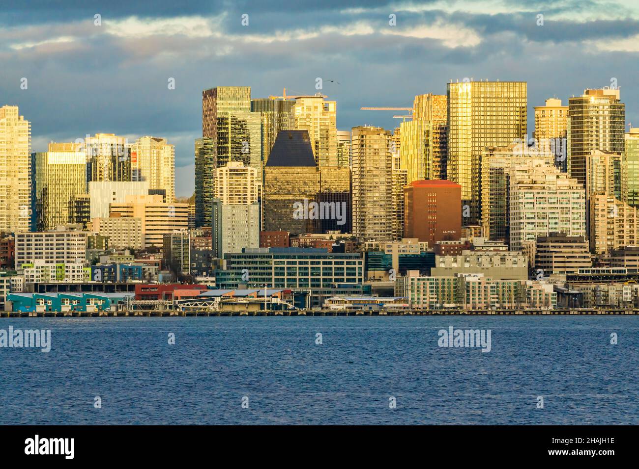 The setting sun makes a section of the city of Seattle shine across ...