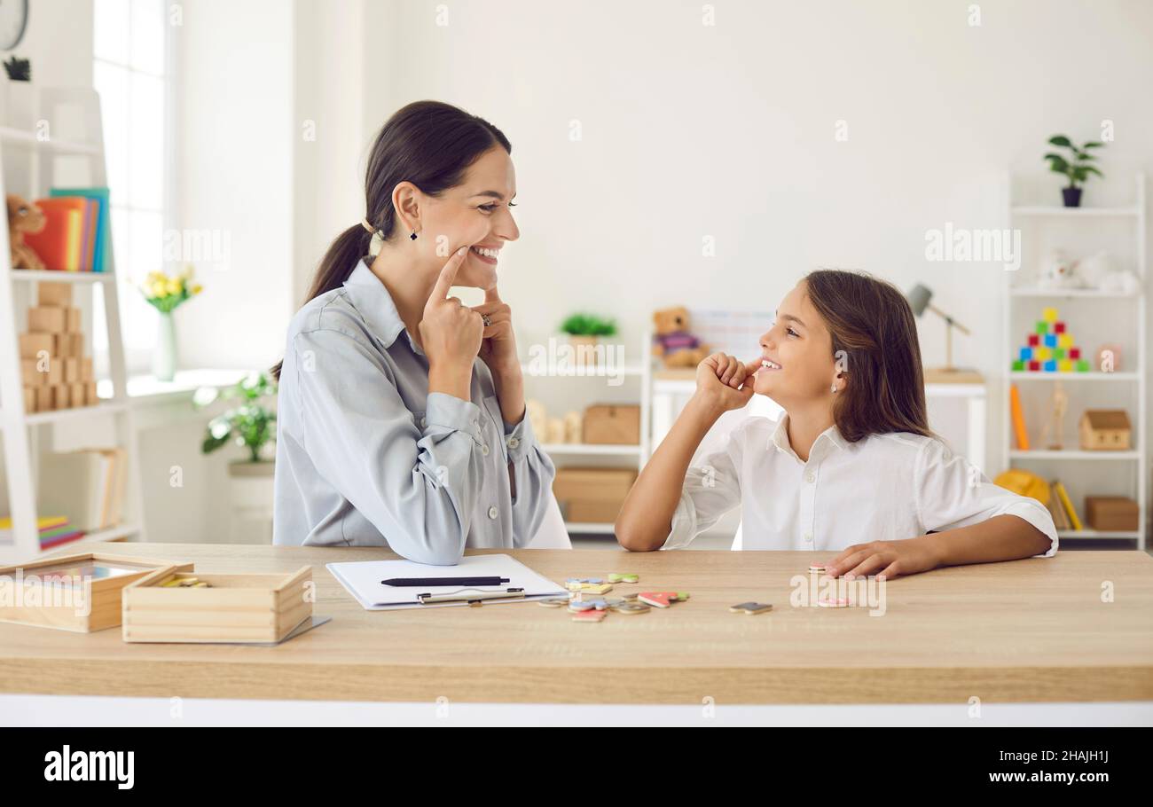 Speech and language therapist helping little child overcome ...