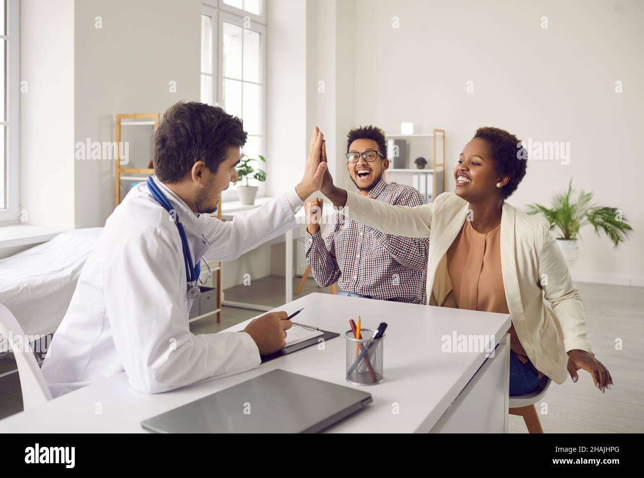 Overjoyed couple patients celebrate good results with doctor Stock ...